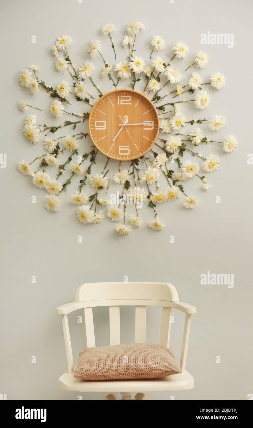 Clock decorated with flowers on wall Stock Photo - Alamy