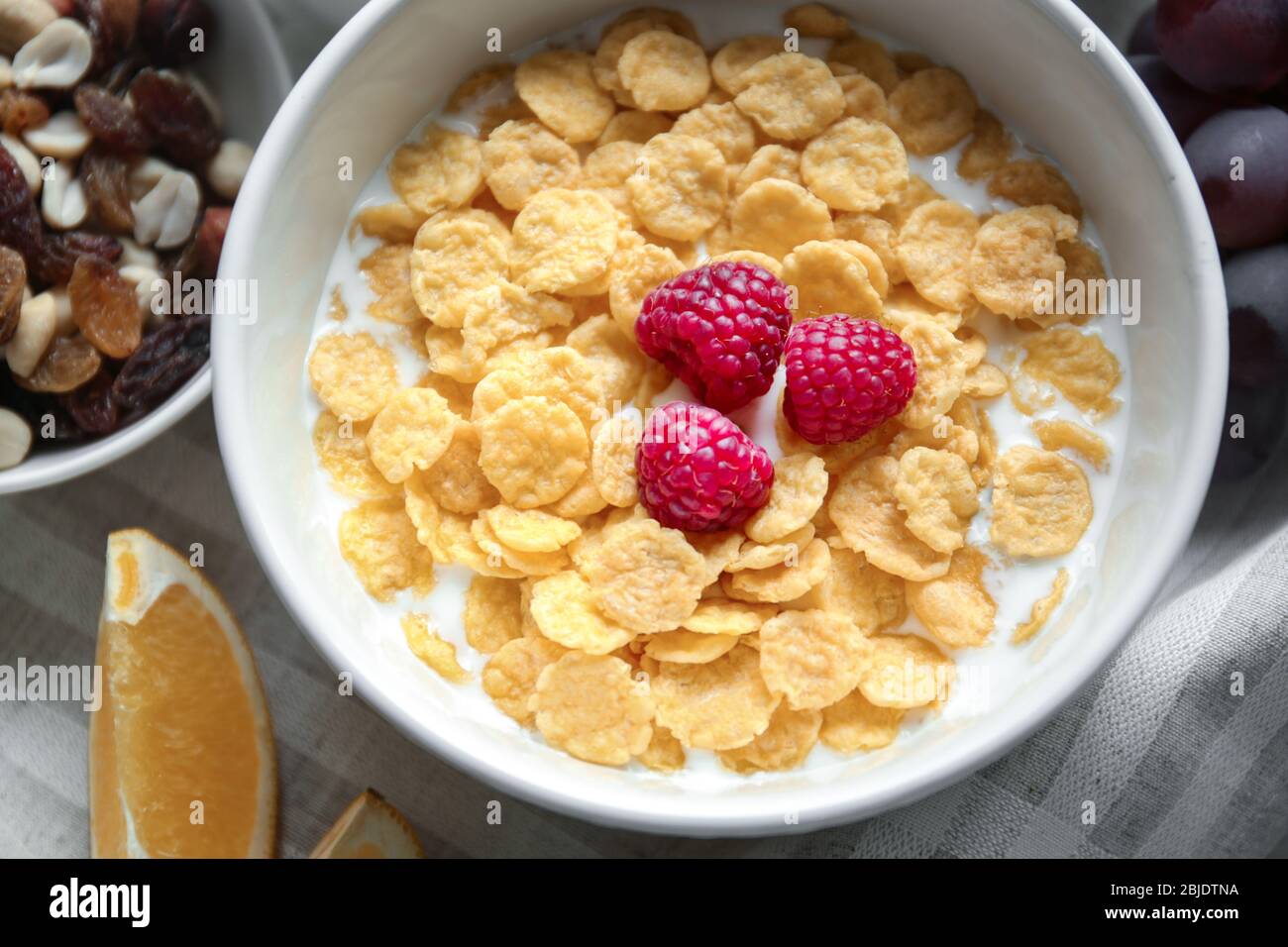 Tasty cornflakes with raspberries on table Stock Photo - Alamy