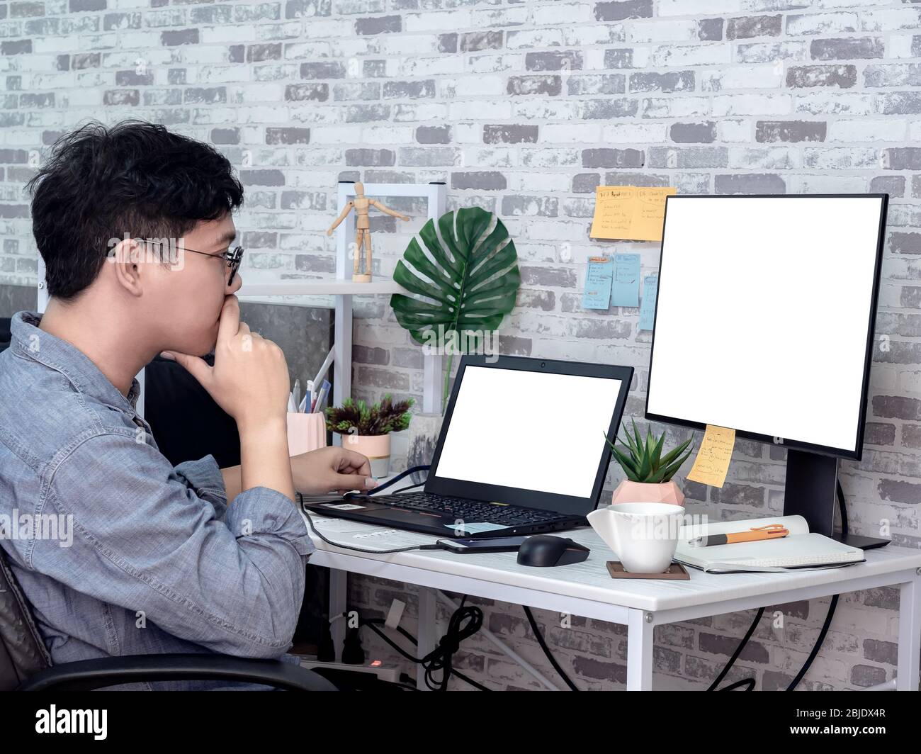 Asian man thinking and working with laptop computer with white blank ...
