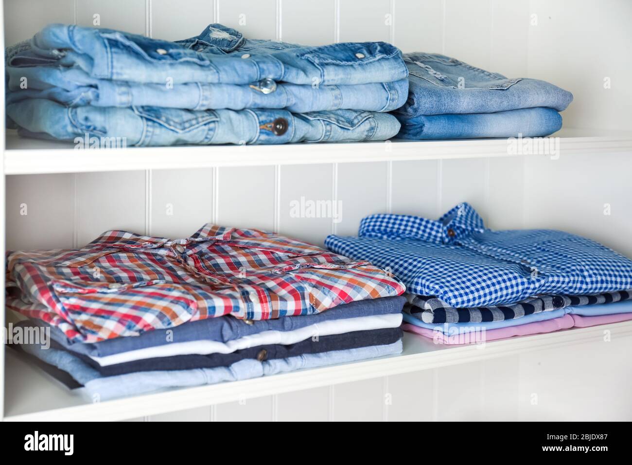 Stack of clothes on shelves Stock Photo - Alamy