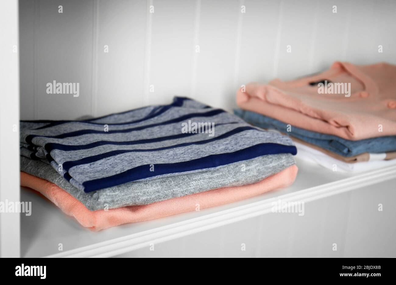 Stack of clothes on shelves Stock Photo - Alamy