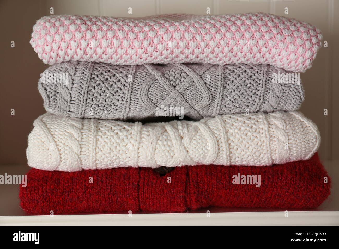 Stack of warm winter clothes on shelves Stock Photo - Alamy