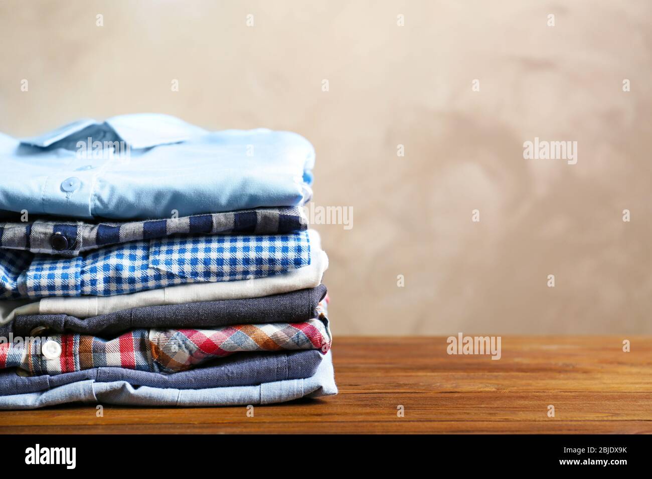 Stack of colorful shirts on table Stock Photo - Alamy