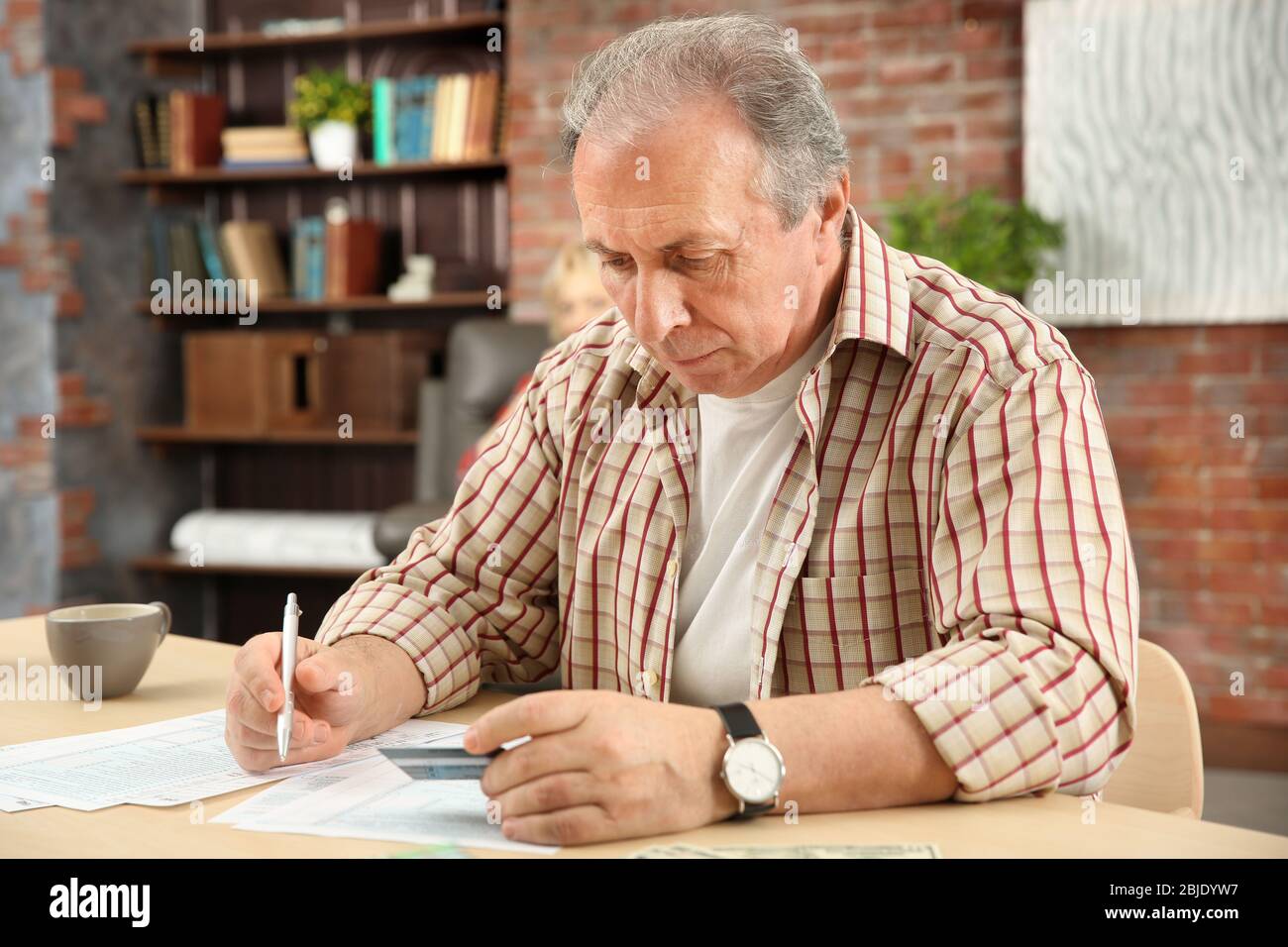 Senior man calculating taxes at home Stock Photo - Alamy