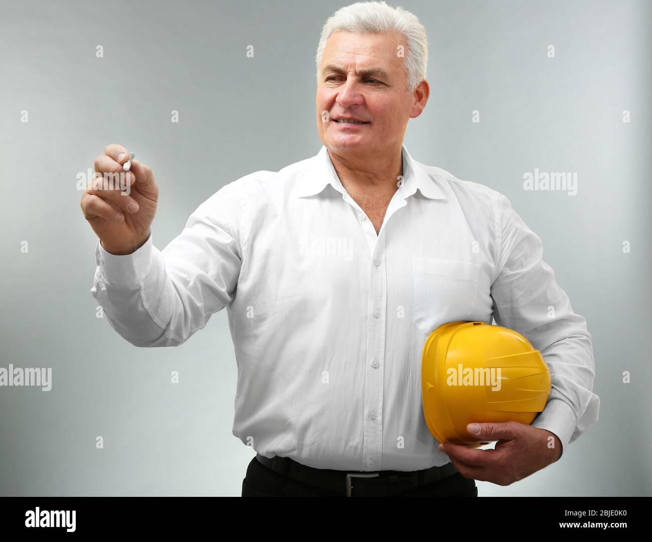 Senior engineer writing something on virtual screen Stock Photo - Alamy