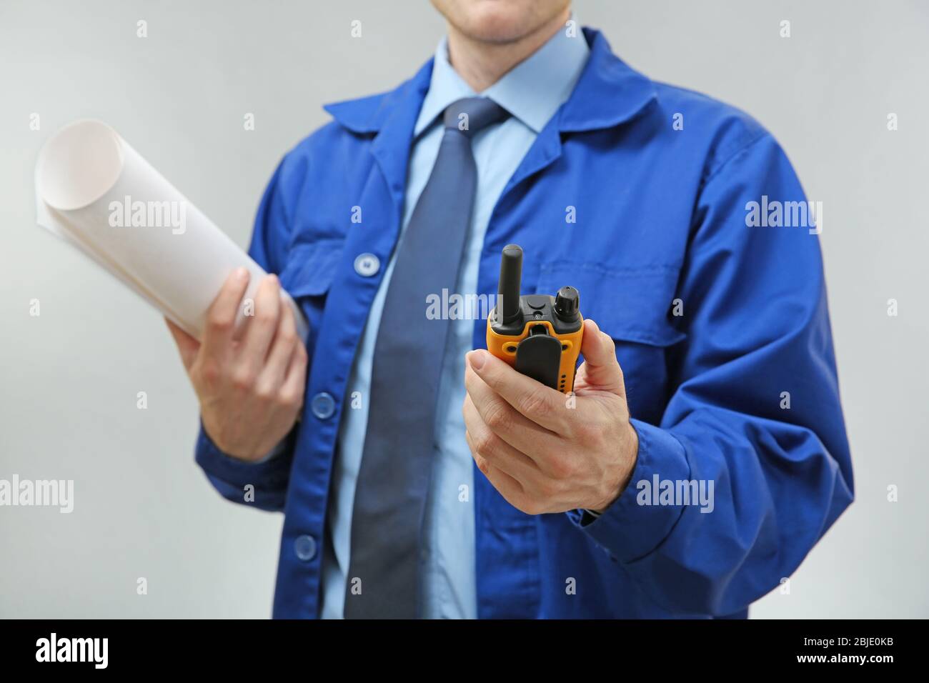 Engineer with drawing and portable radio transmitter on light ...