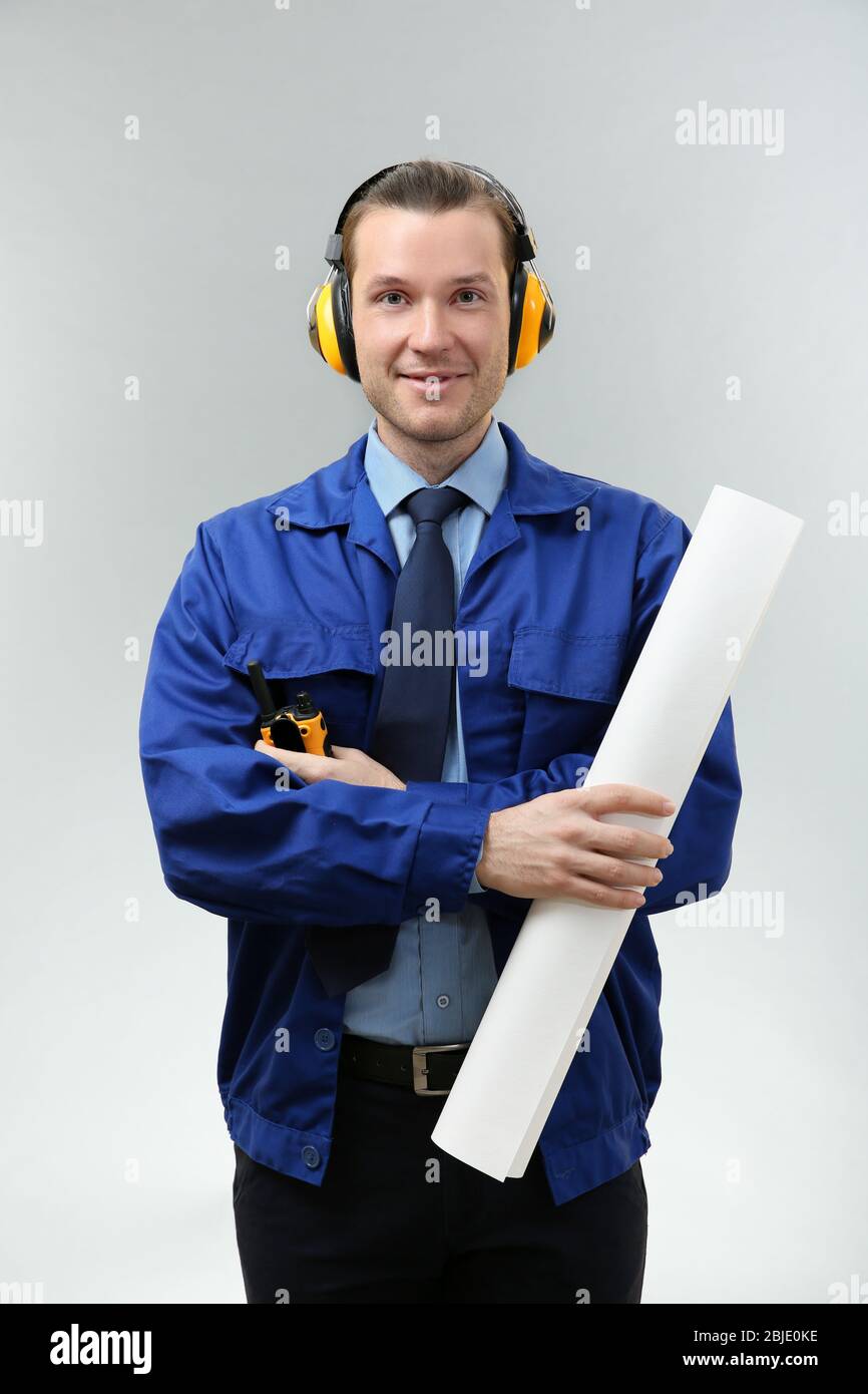 Handsome engineer with headphones, drawing and portable radio ...