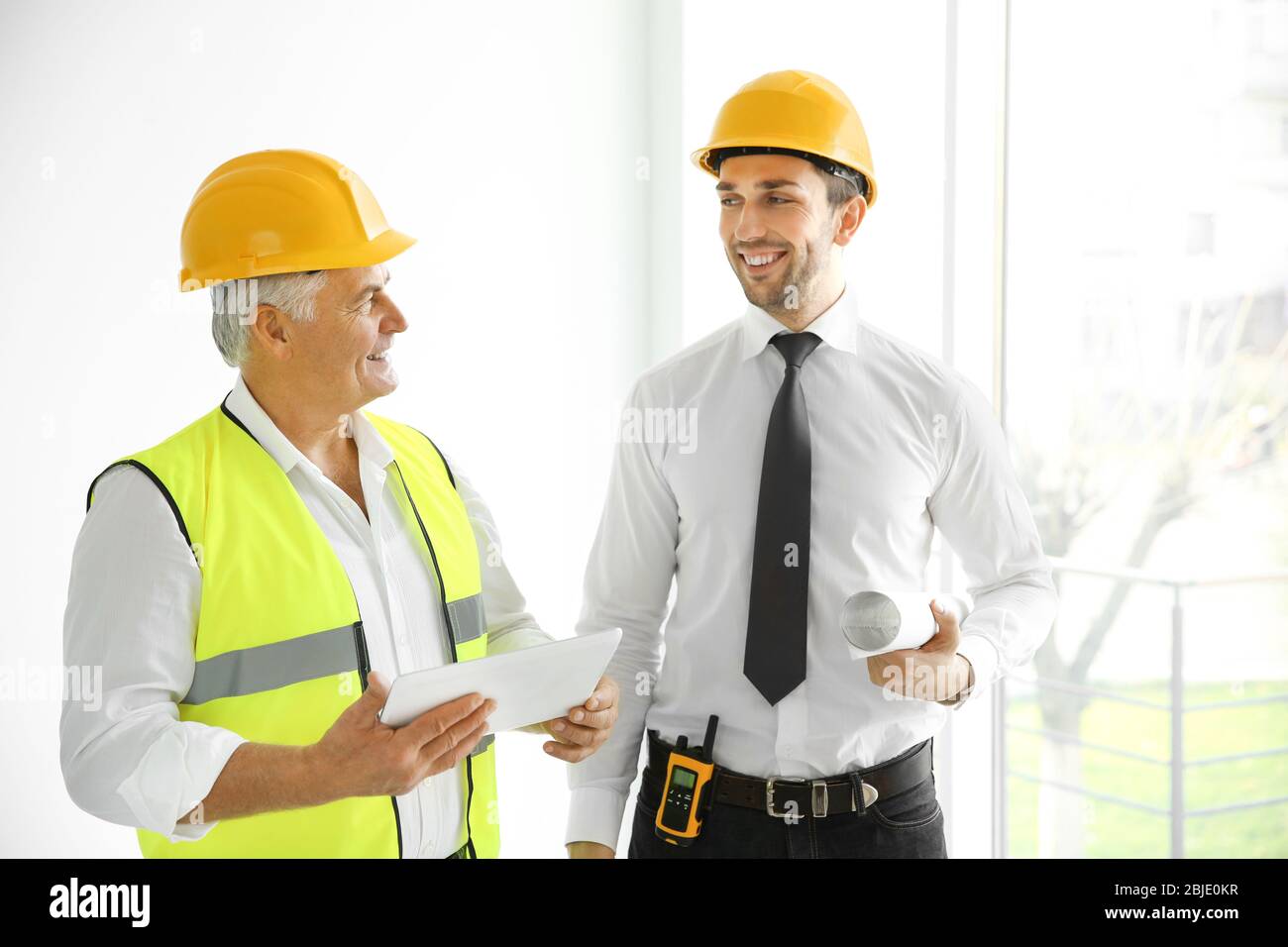 Handsome engineer and worker with tablet computer in new building Stock ...