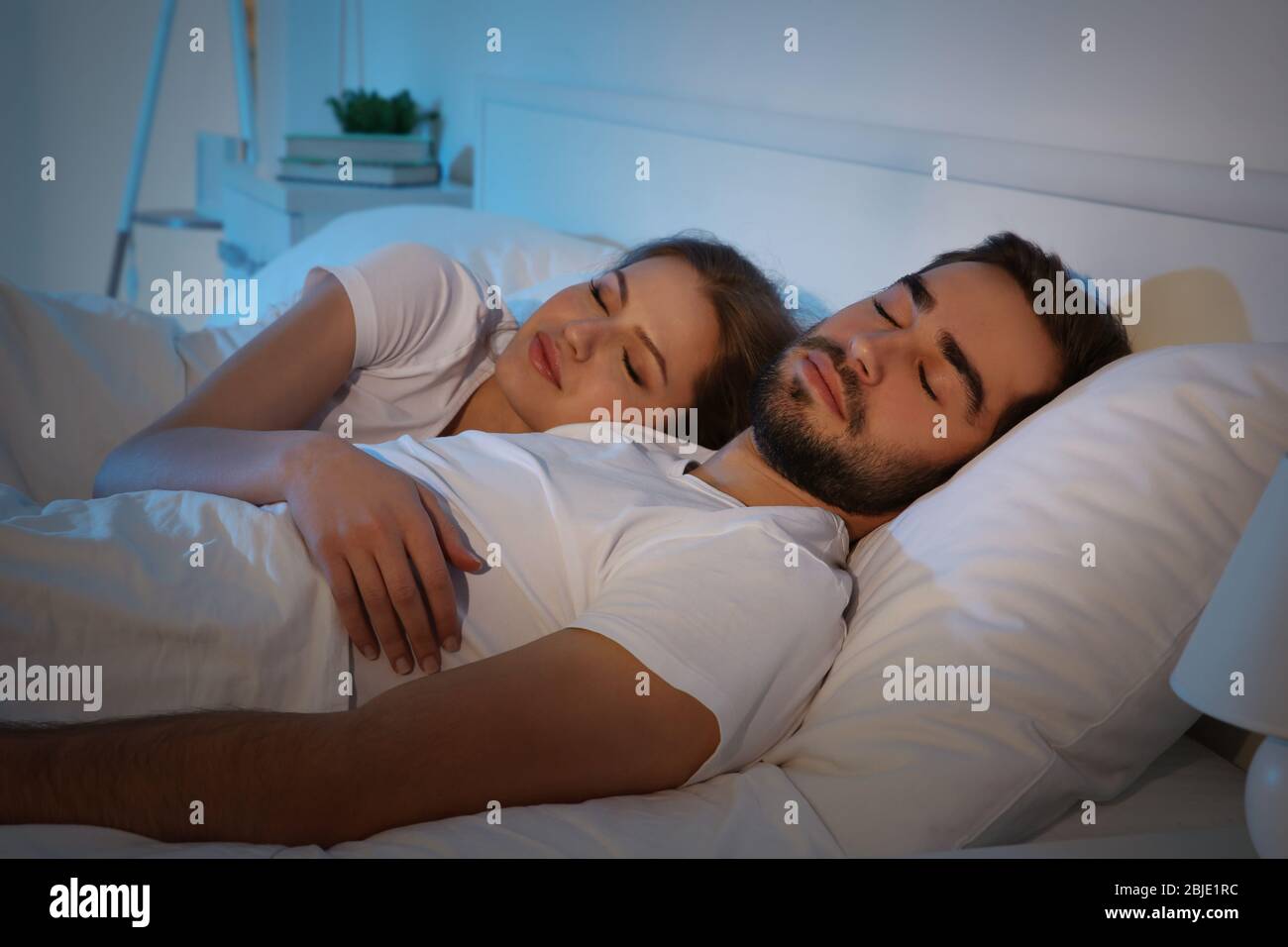 Young cute couple sleeping together in bed Stock Photo - Alamy