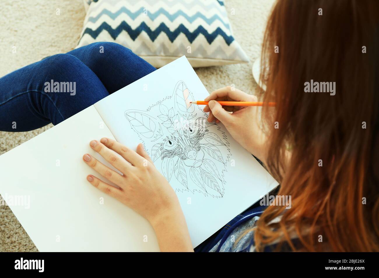 Young woman sitting with coloring pictures for adults Stock Photo - Alamy