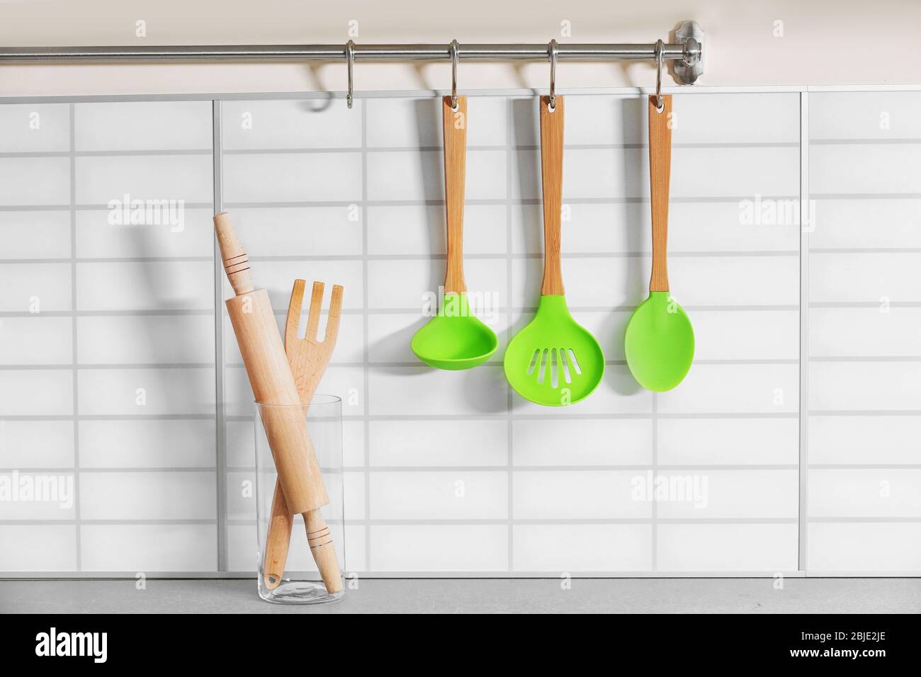 Set of wooden kitchen utensils hanging on wall Stock Photo - Alamy