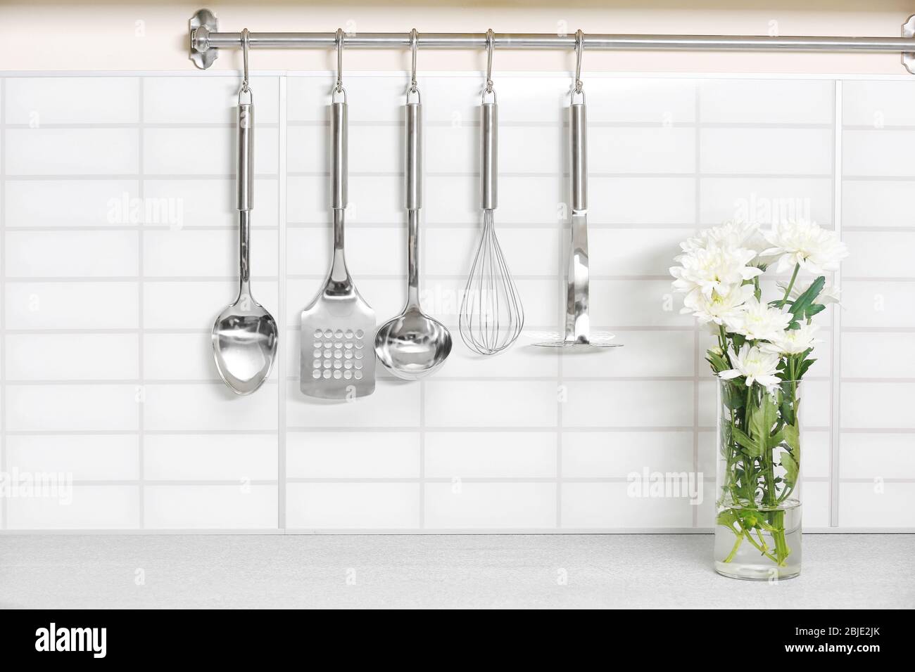 Set of metal kitchen utensils hanging on wall Stock Photo - Alamy