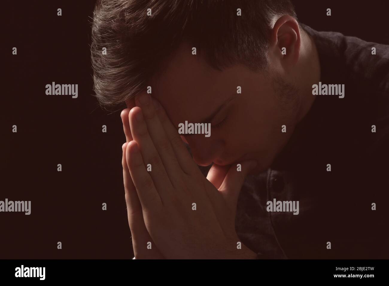 Handsome depressed man on black background Stock Photo - Alamy