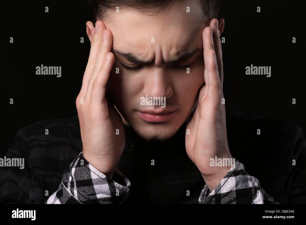 Handsome depressed man on black background Stock Photo - Alamy