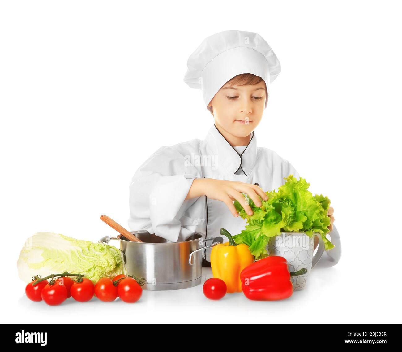 Cute boy in chef uniform preparing tasty soup, on white background ...