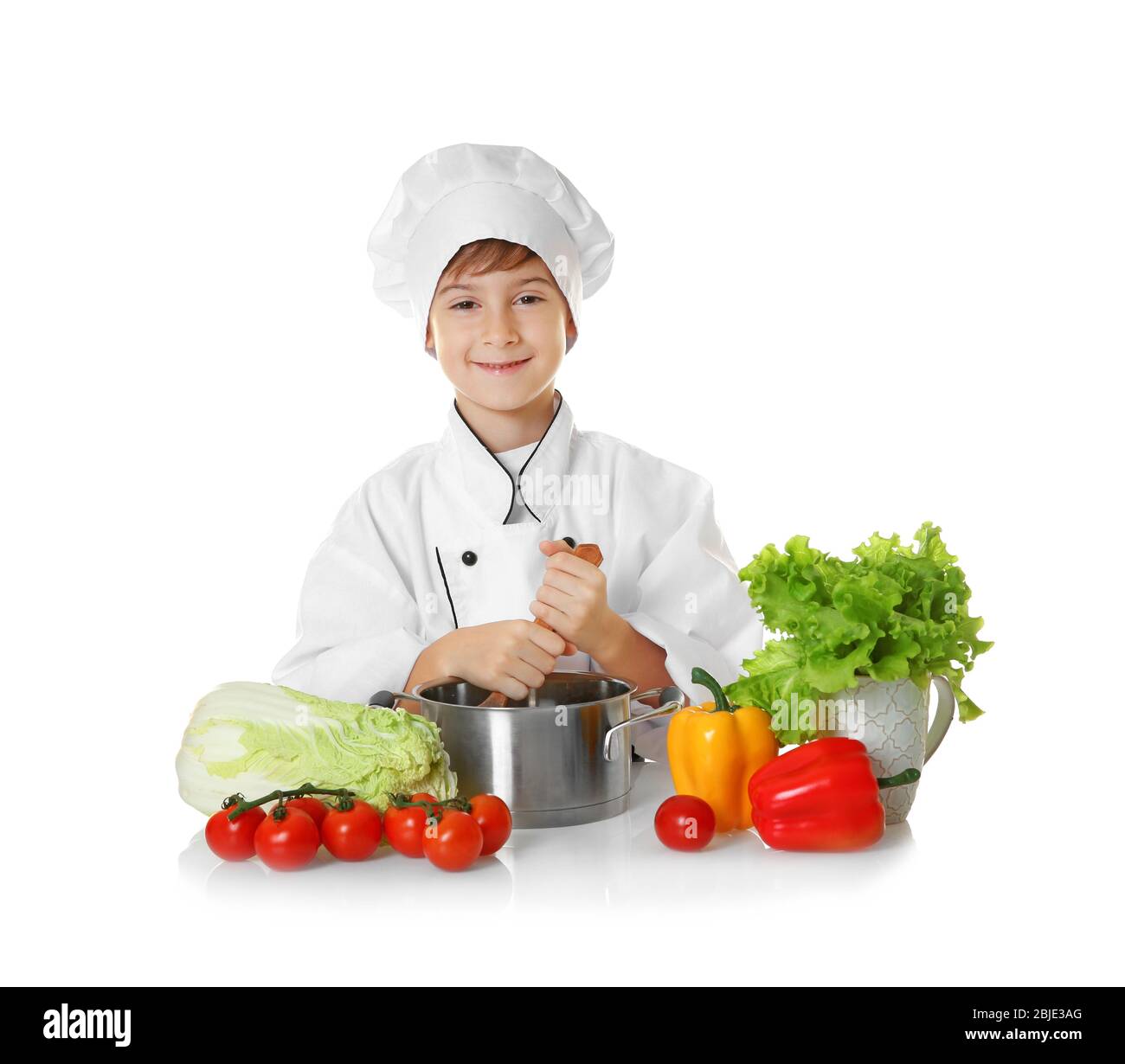 Cute boy in chef uniform preparing tasty soup, on white background ...