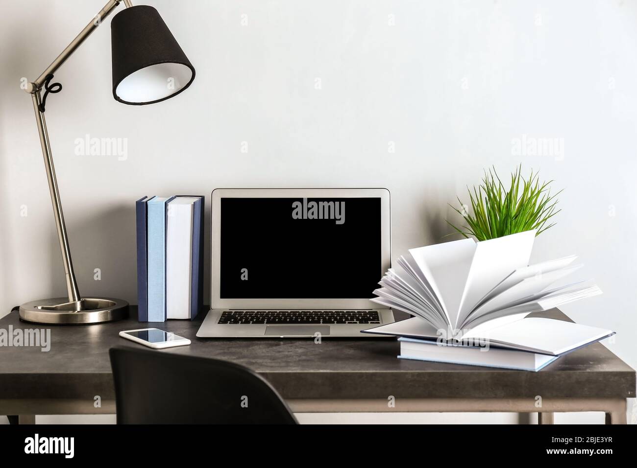 Workplace with laptop, books and lamp Stock Photo - Alamy