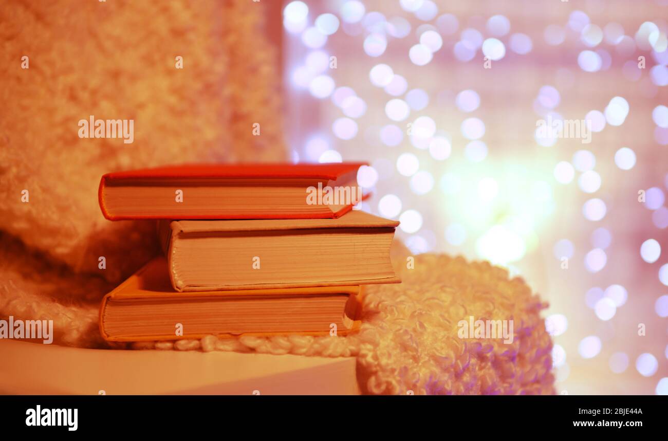 Books on chair covered with plaid, against defocused lights Stock Photo ...