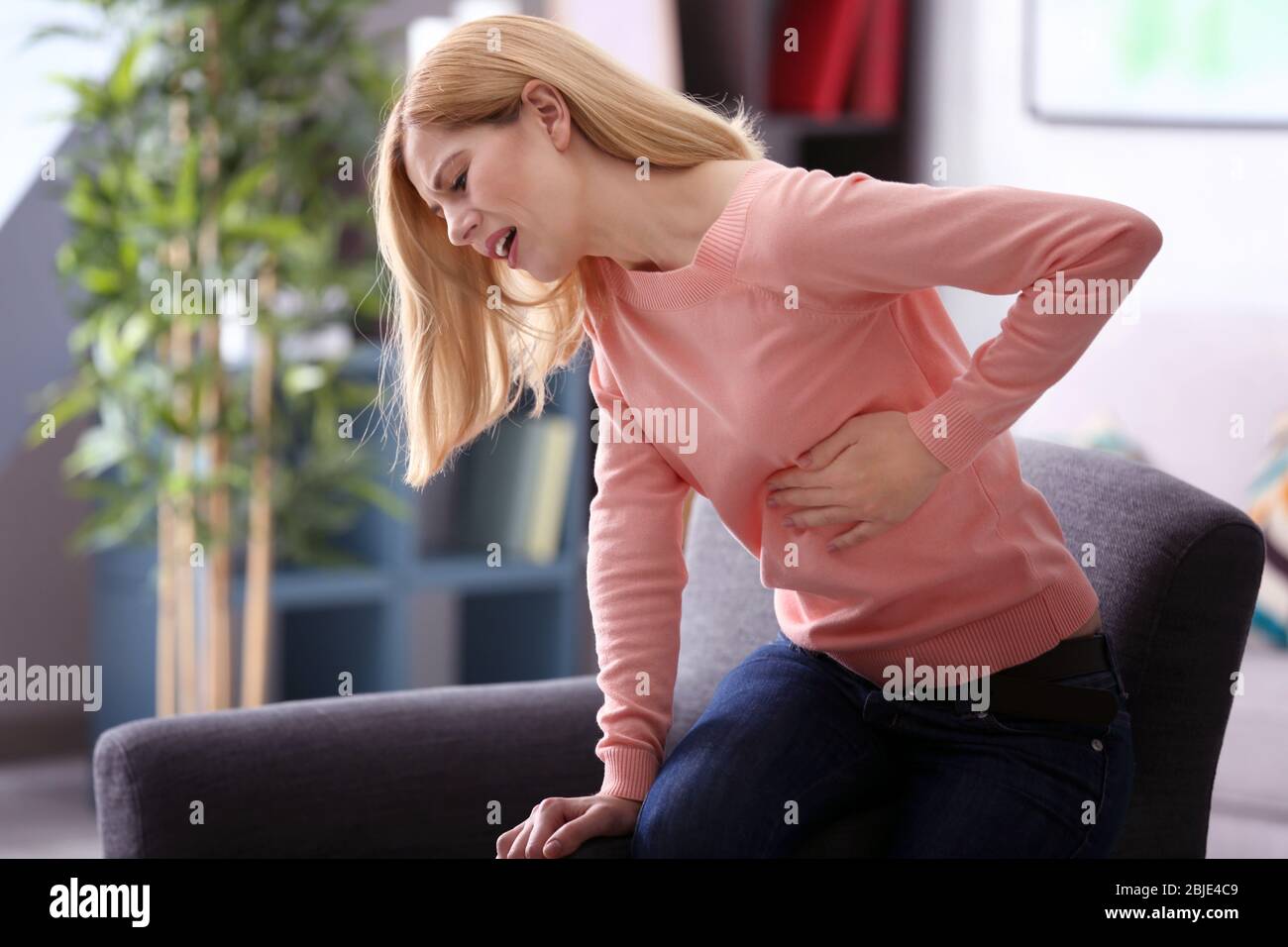 Young woman having heart pain, at home Stock Photo - Alamy