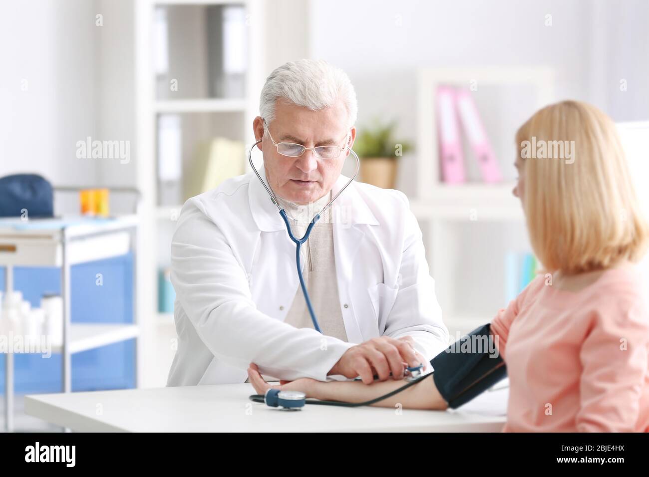 Doctor measuring blood pressure of patient Stock Photo - Alamy