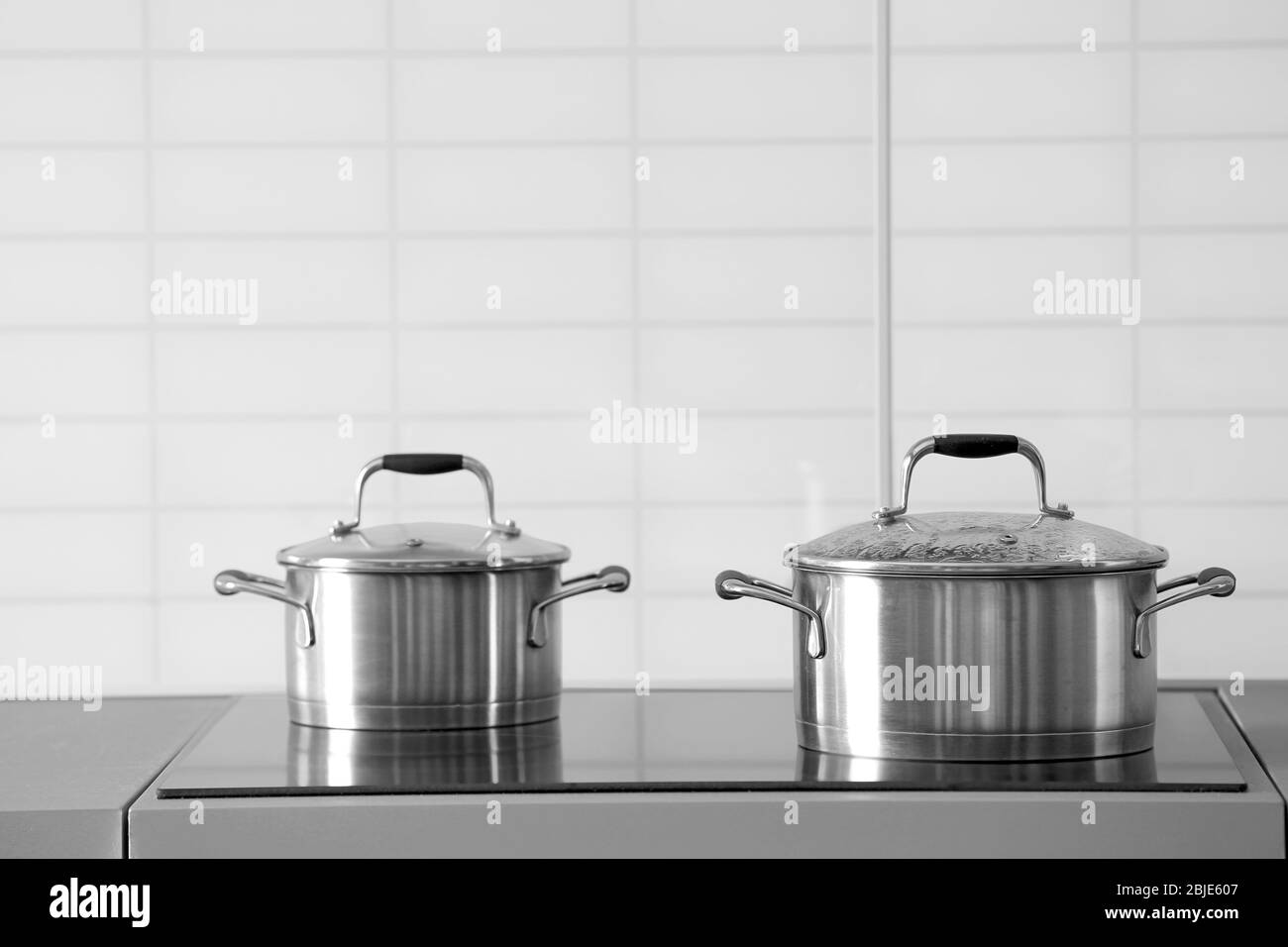 Metal pans on modern kitchen stove Stock Photo - Alamy