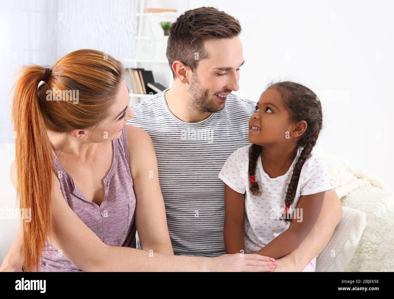 Happy interracial family sitting on sofa Stock Photo - Alamy