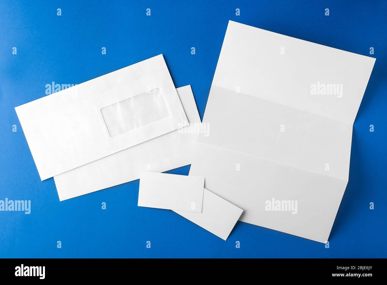 Blank brochure, envelope and card on blue background Stock Photo - Alamy