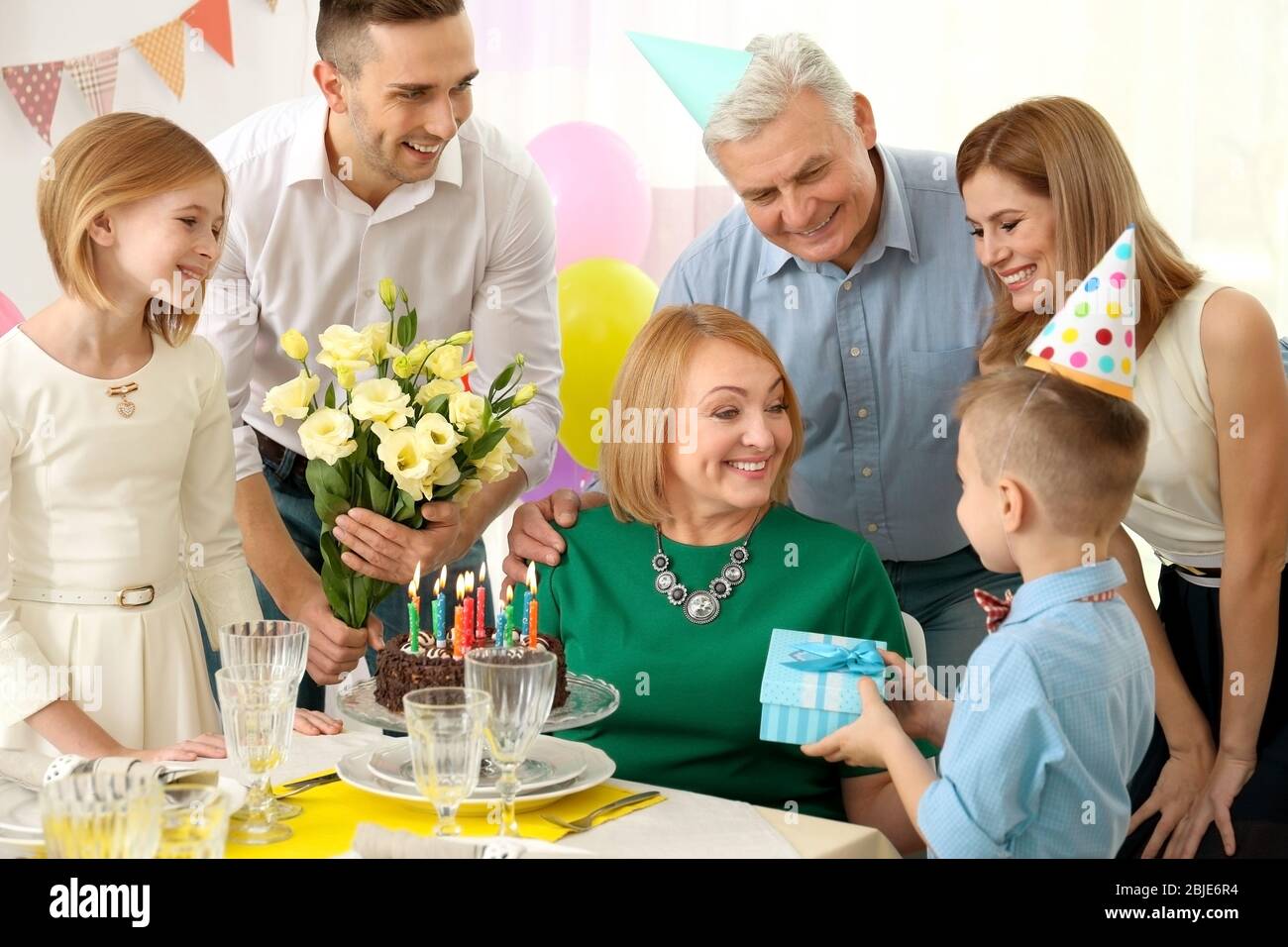Family celebrating grandmother's birthday together Stock Photo - Alamy