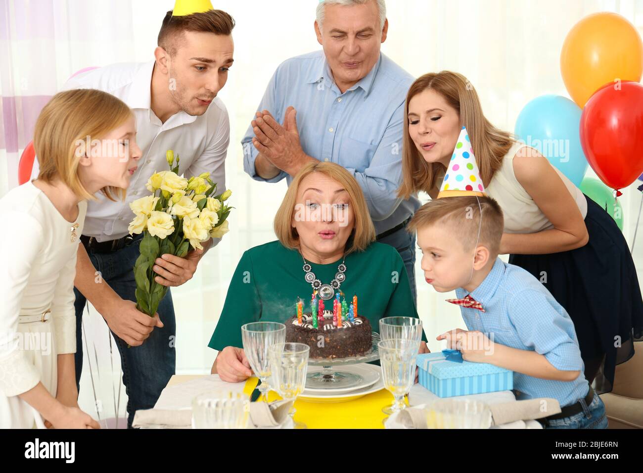 Family celebrating grandmother's birthday together Stock Photo - Alamy