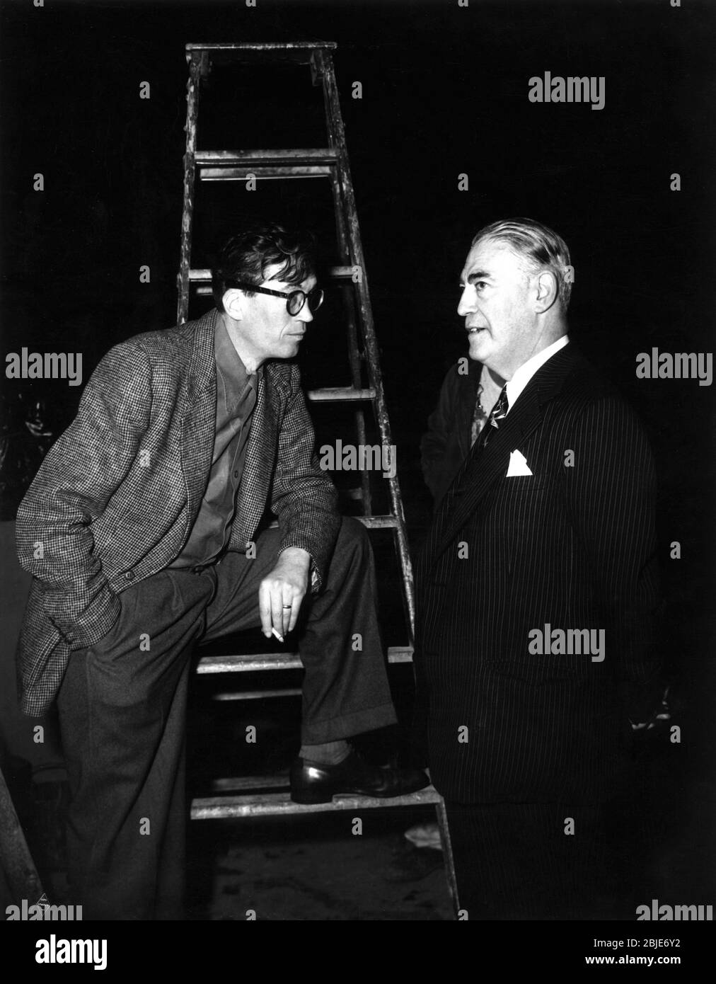 Director JOHN HUSTON on set candid with visitor MAX MILDER, president ...