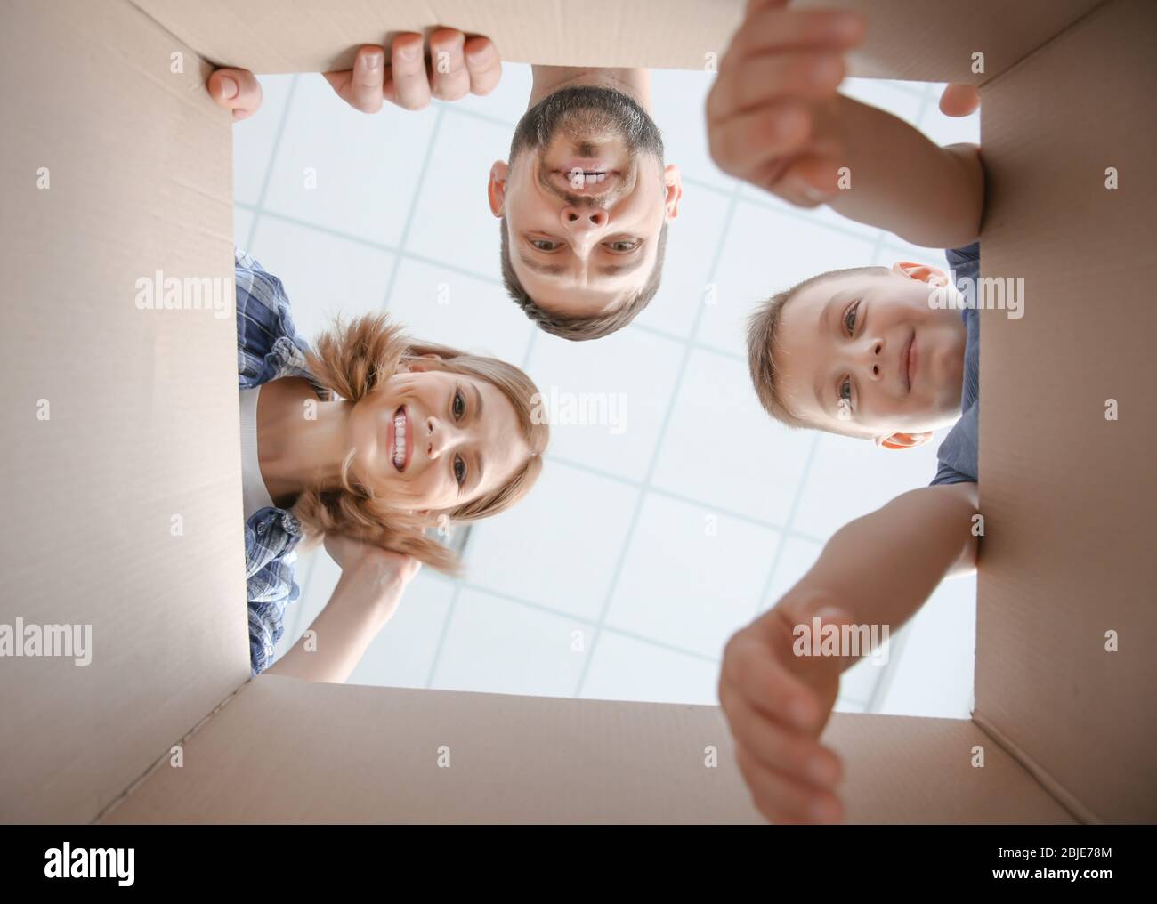 Happy family looking through box. Moving concept Stock Photo - Alamy