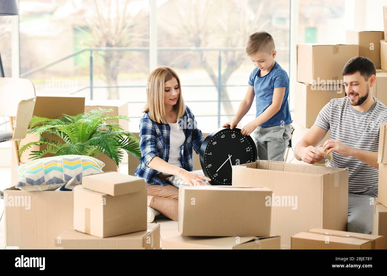 Happy family packing boxes in room. Moving concept Stock Photo - Alamy