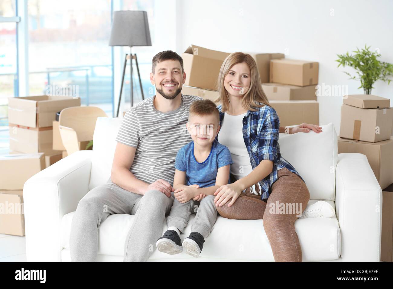 Happy family with cardboard boxes. Moving concept Stock Photo - Alamy