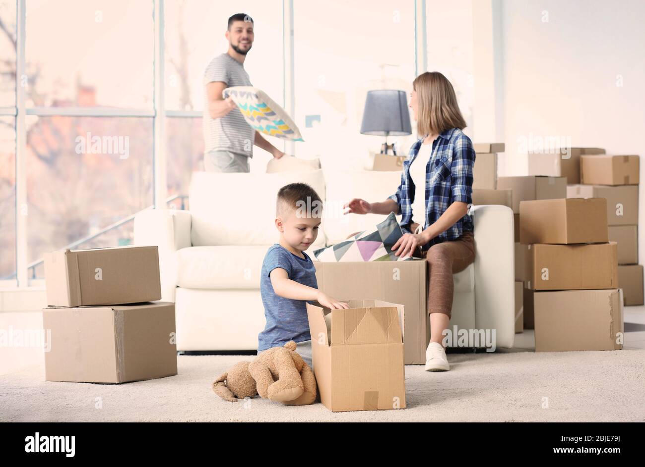 Happy family packing boxes in room. Moving concept Stock Photo - Alamy