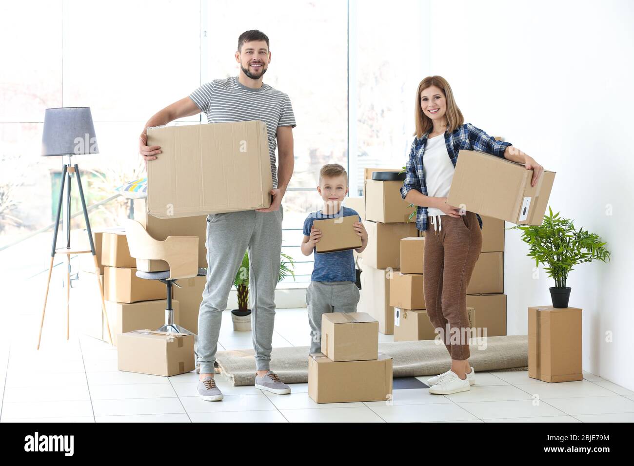 Happy family with cardboard boxes. Moving concept Stock Photo - Alamy