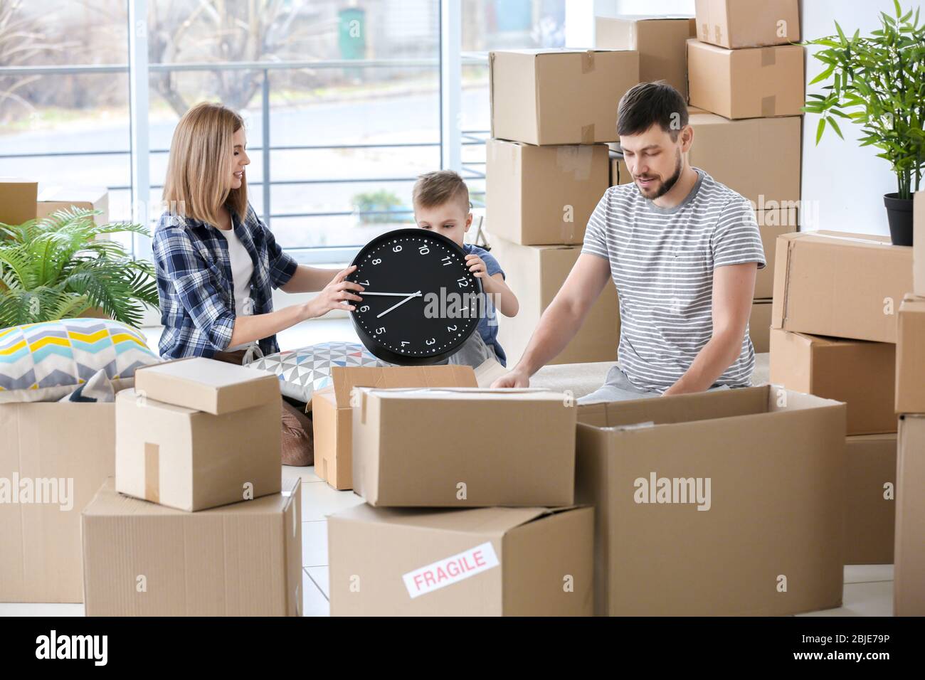 Happy family packing boxes in room. Moving concept Stock Photo - Alamy