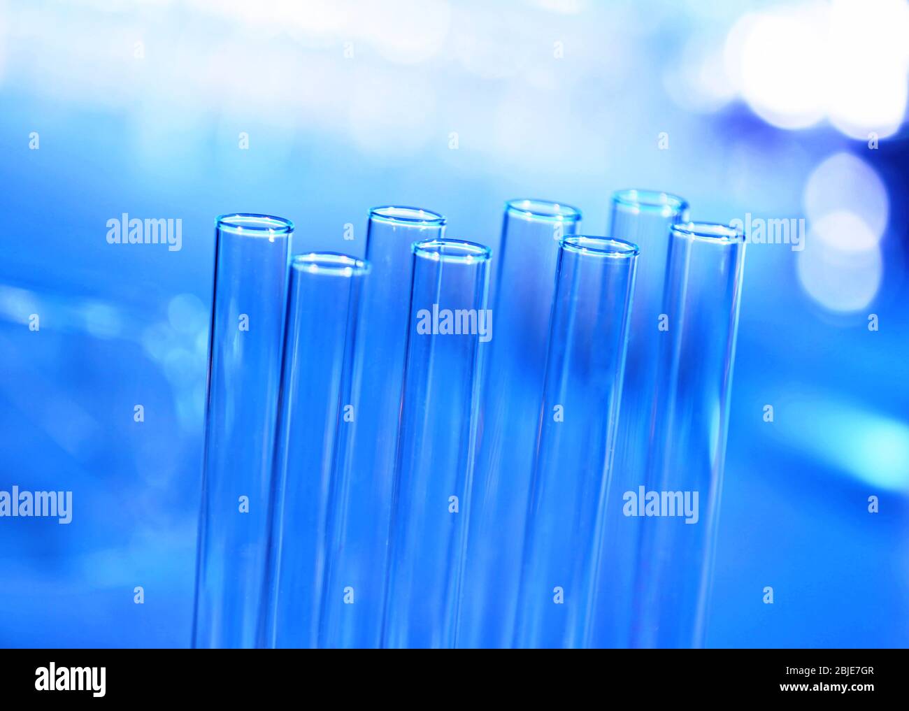 Test tubes on blurred background Stock Photo - Alamy