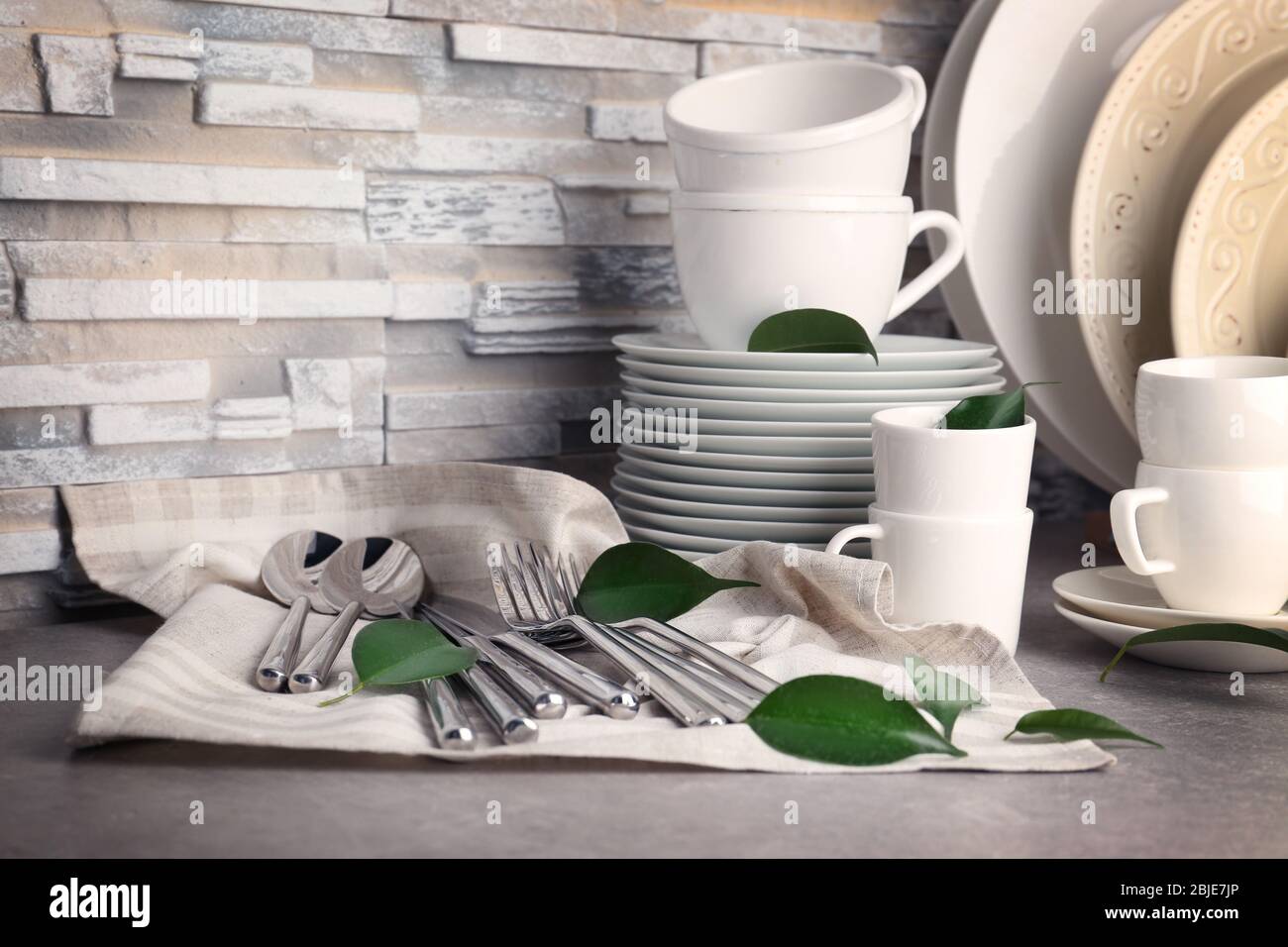 Set of rustic dinnerware on light brick background Stock Photo - Alamy