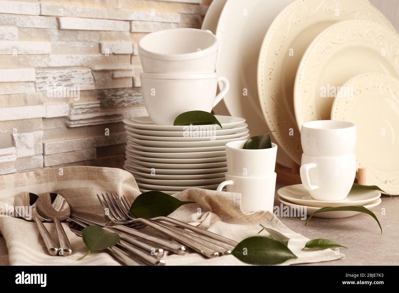 Set of rustic dinnerware on light brick background Stock Photo - Alamy