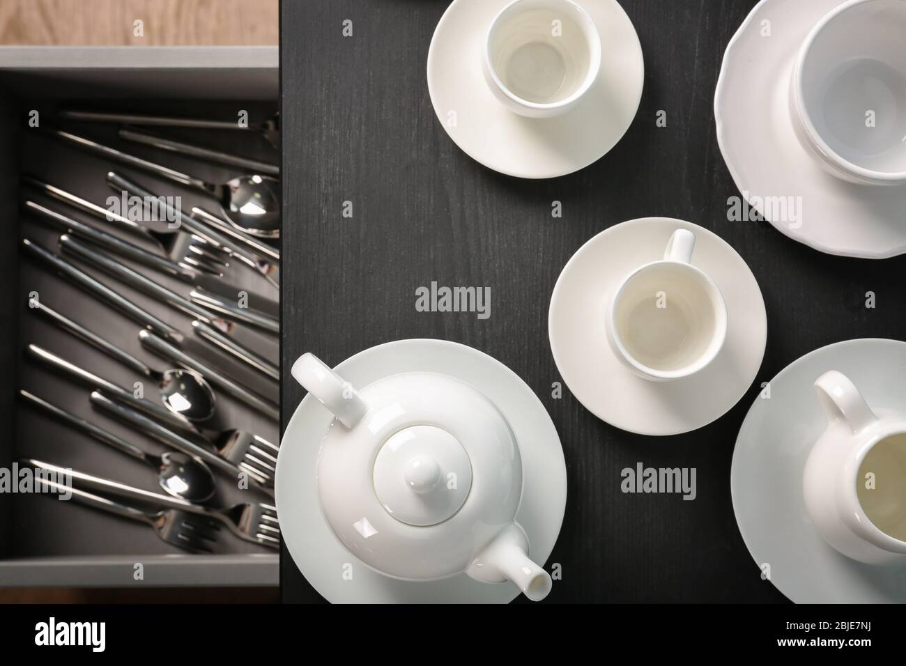 Simple white tea set on black wooden table Stock Photo - Alamy