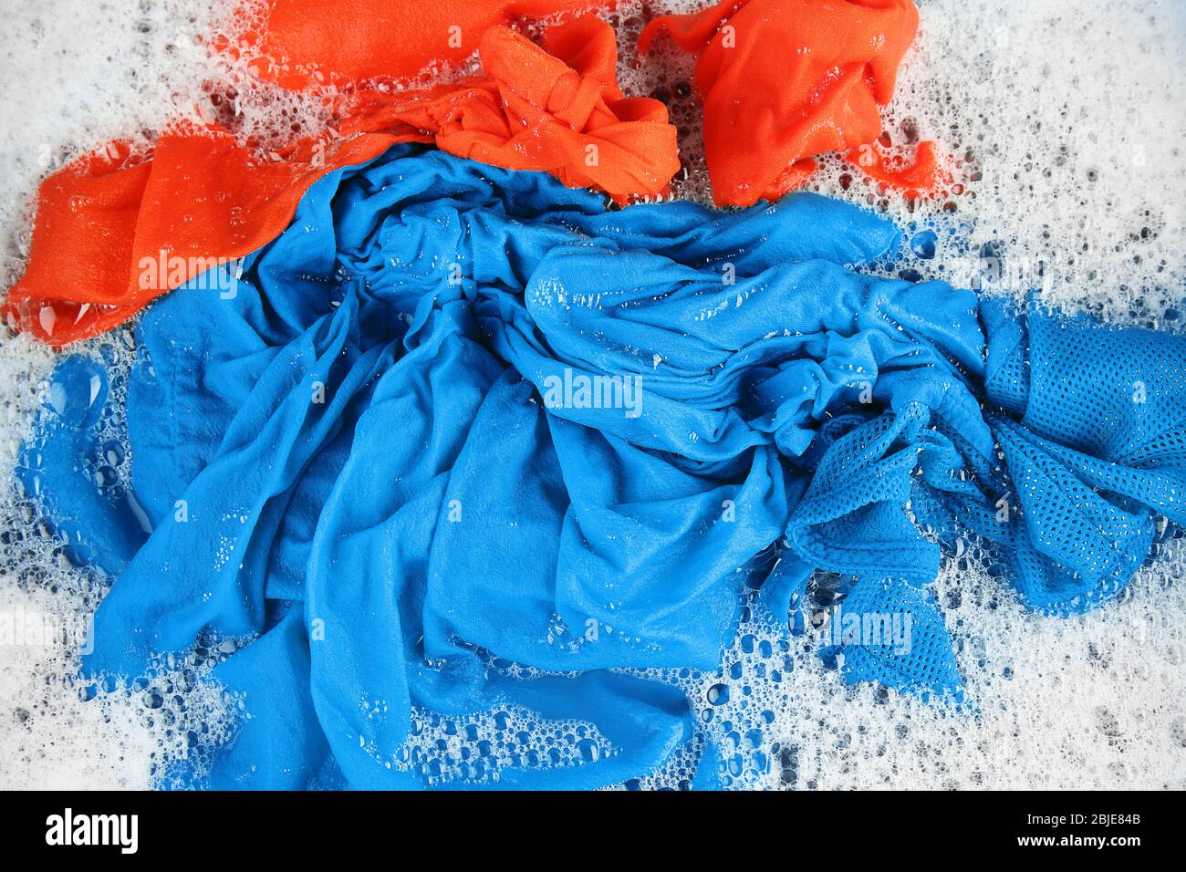 Wet color clothes with foam, close up Stock Photo - Alamy