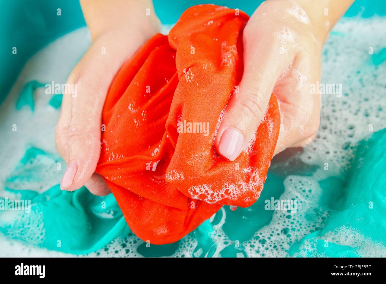 Female hands washing color clothes in basin Stock Photo - Alamy