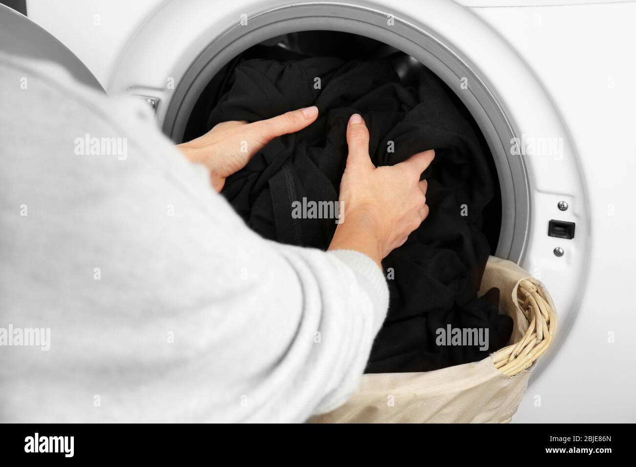 Female hands getting out clean clothes from washing machine Stock Photo ...