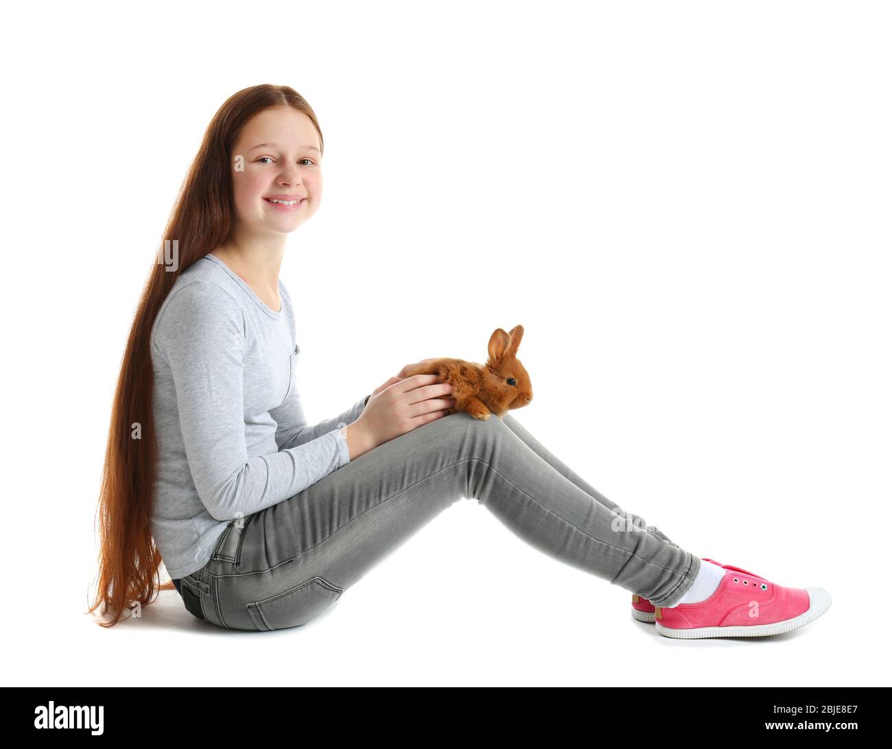 Cute girl holding small rabbit on white background Stock Photo - Alamy