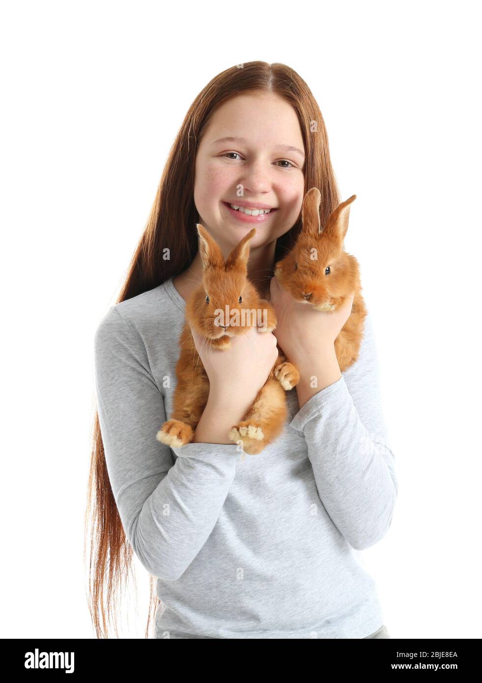 Cute girl holding small rabbits on white background Stock Photo - Alamy