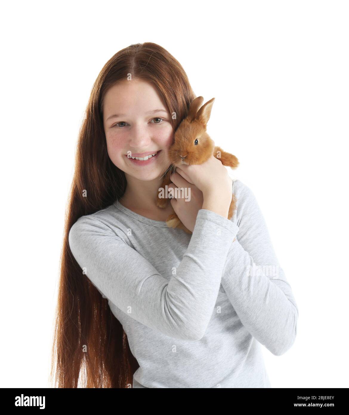 Cute girl holding small rabbit on white background Stock Photo - Alamy