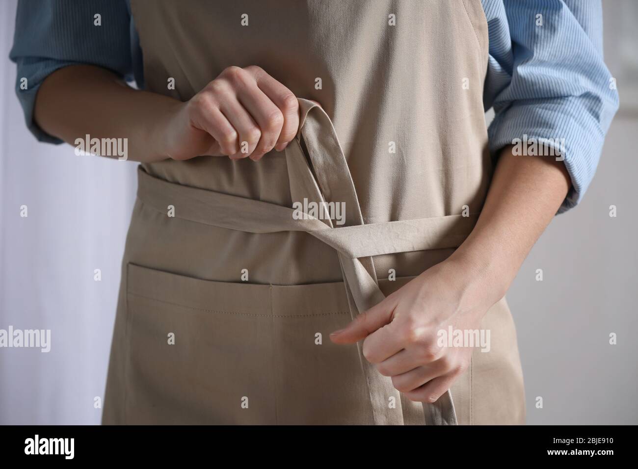 Female hands tying apron, closeup Stock Photo - Alamy
