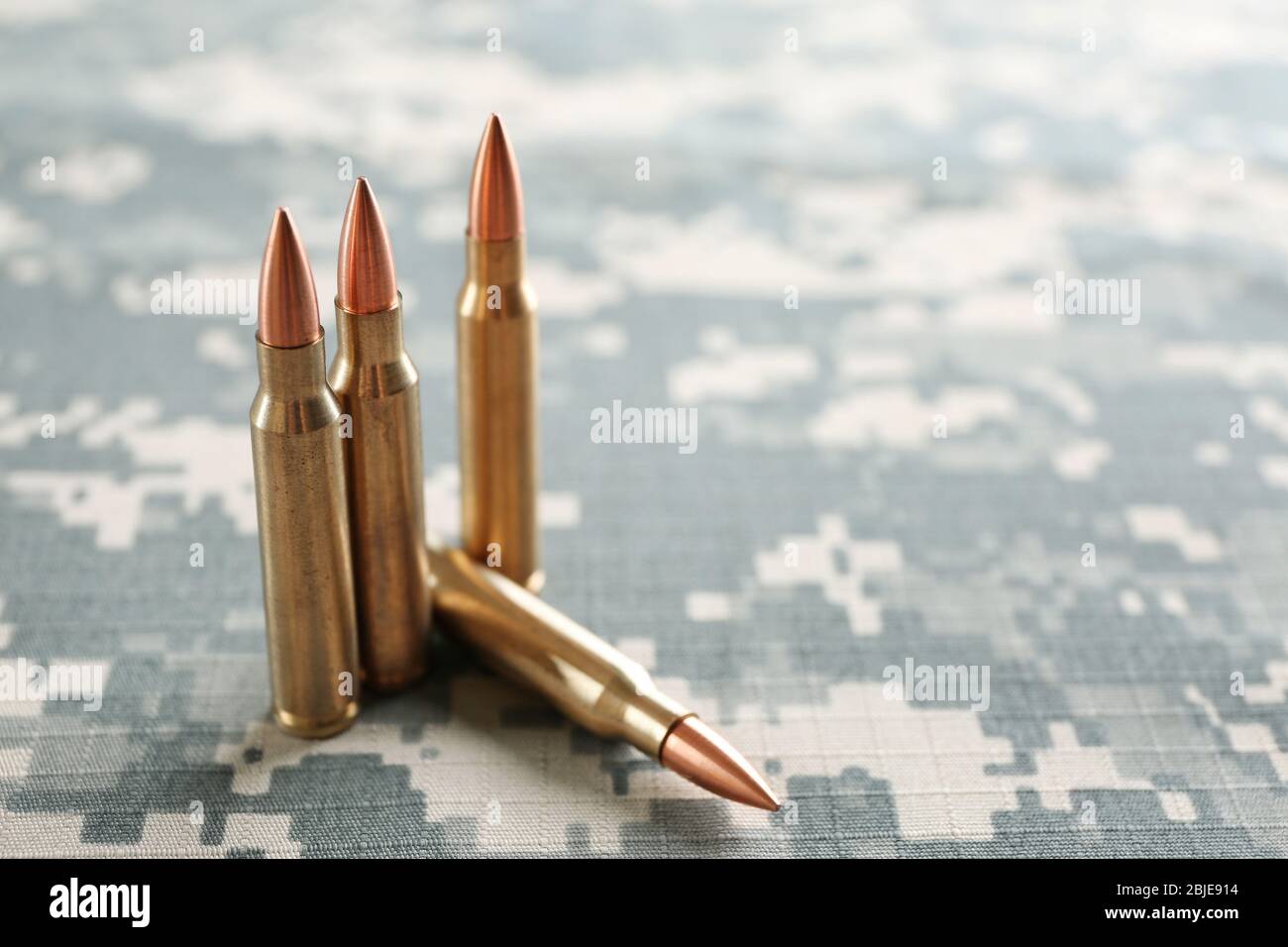 Bullets on camouflage background Stock Photo - Alamy