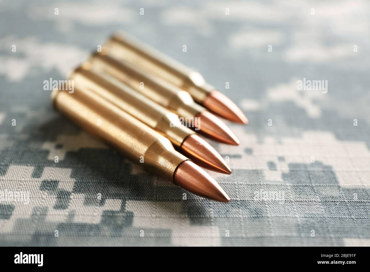 Bullets on camouflage background Stock Photo - Alamy