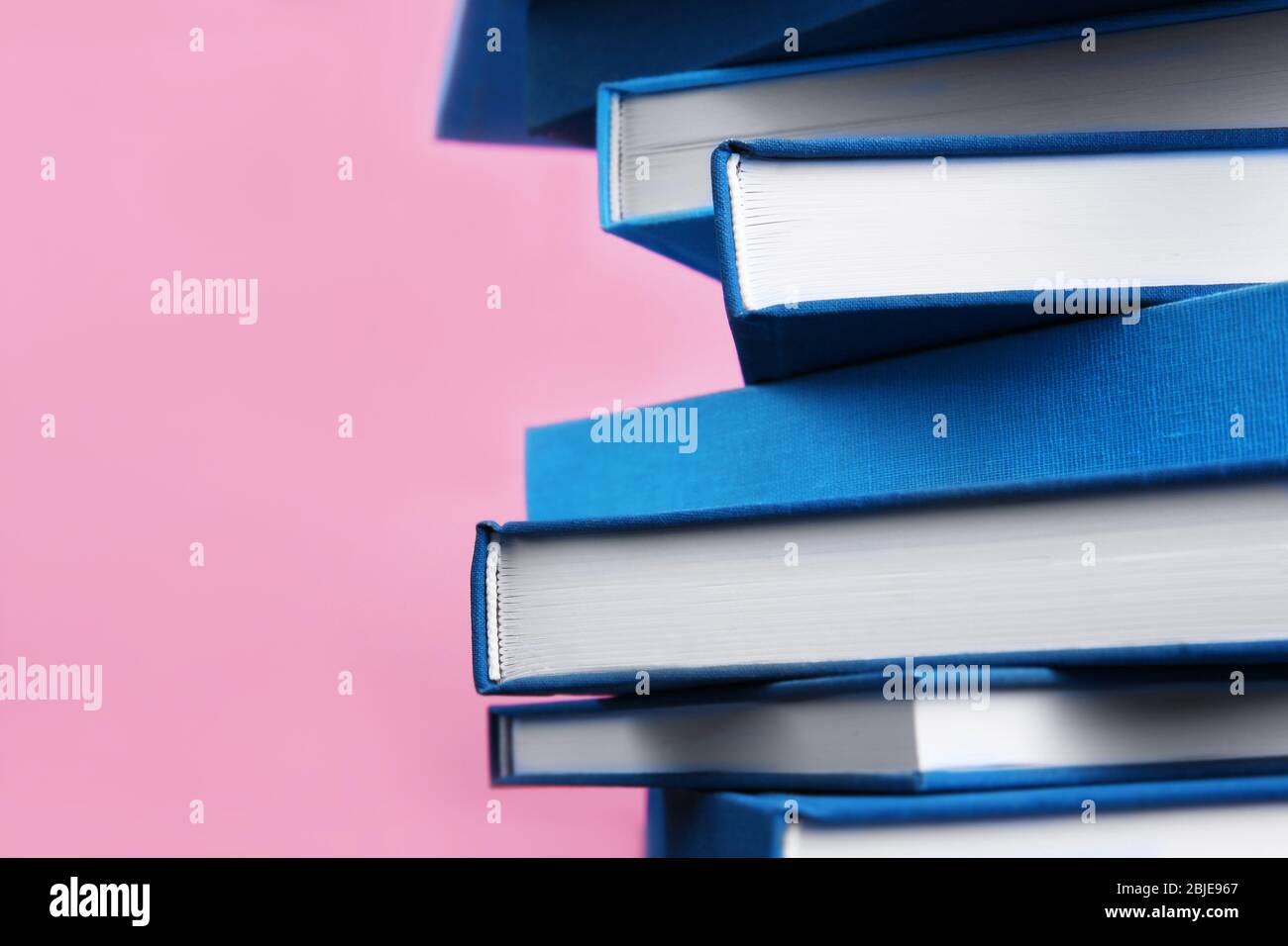 Blue books on pink background Stock Photo - Alamy